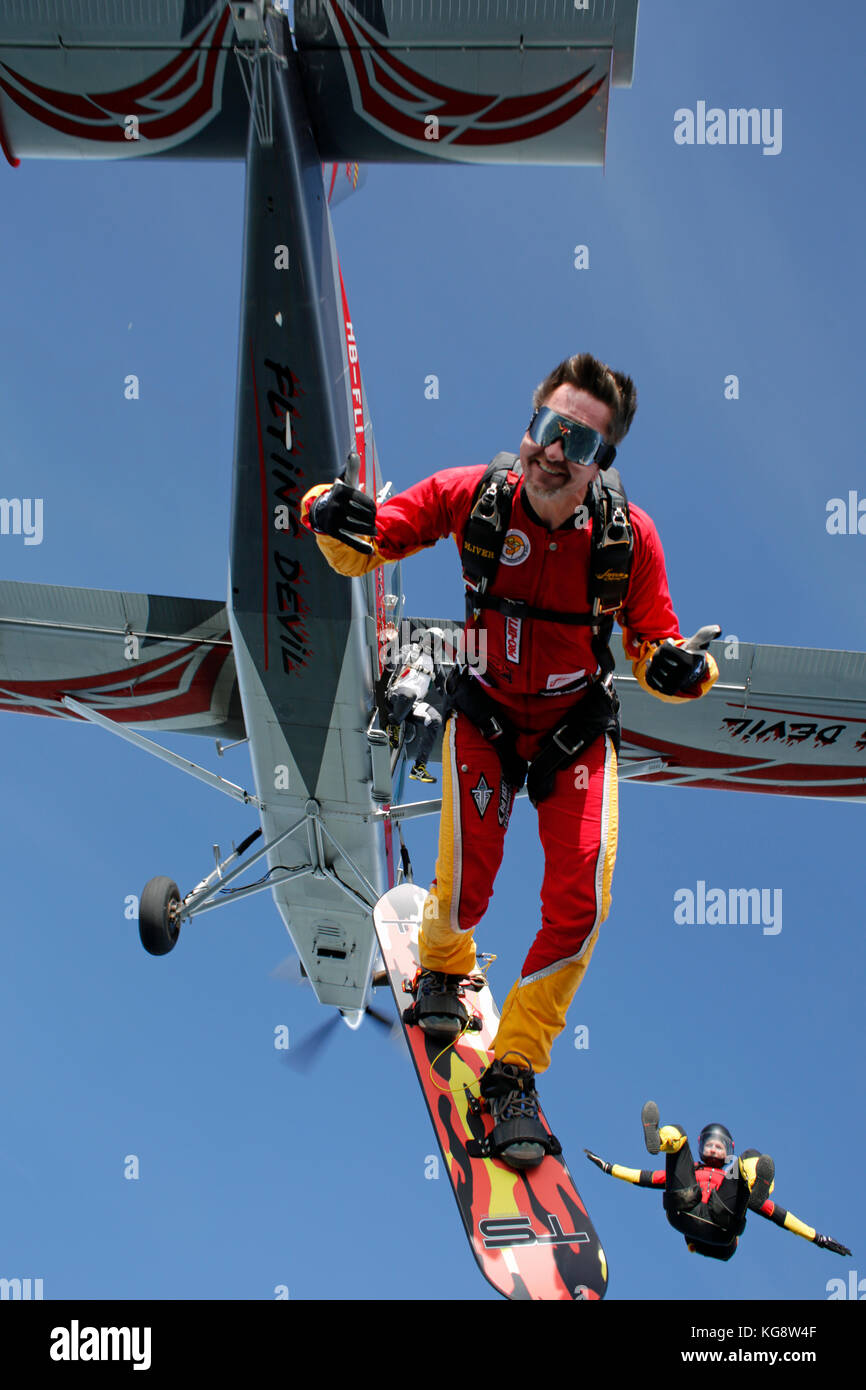 Skysurfer is exiting from an aircraft with a big smile on his face. He ...