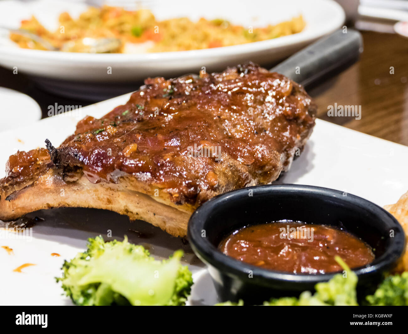 Rack of ribs on plate with sauce and vegetables Stock Photo - Alamy