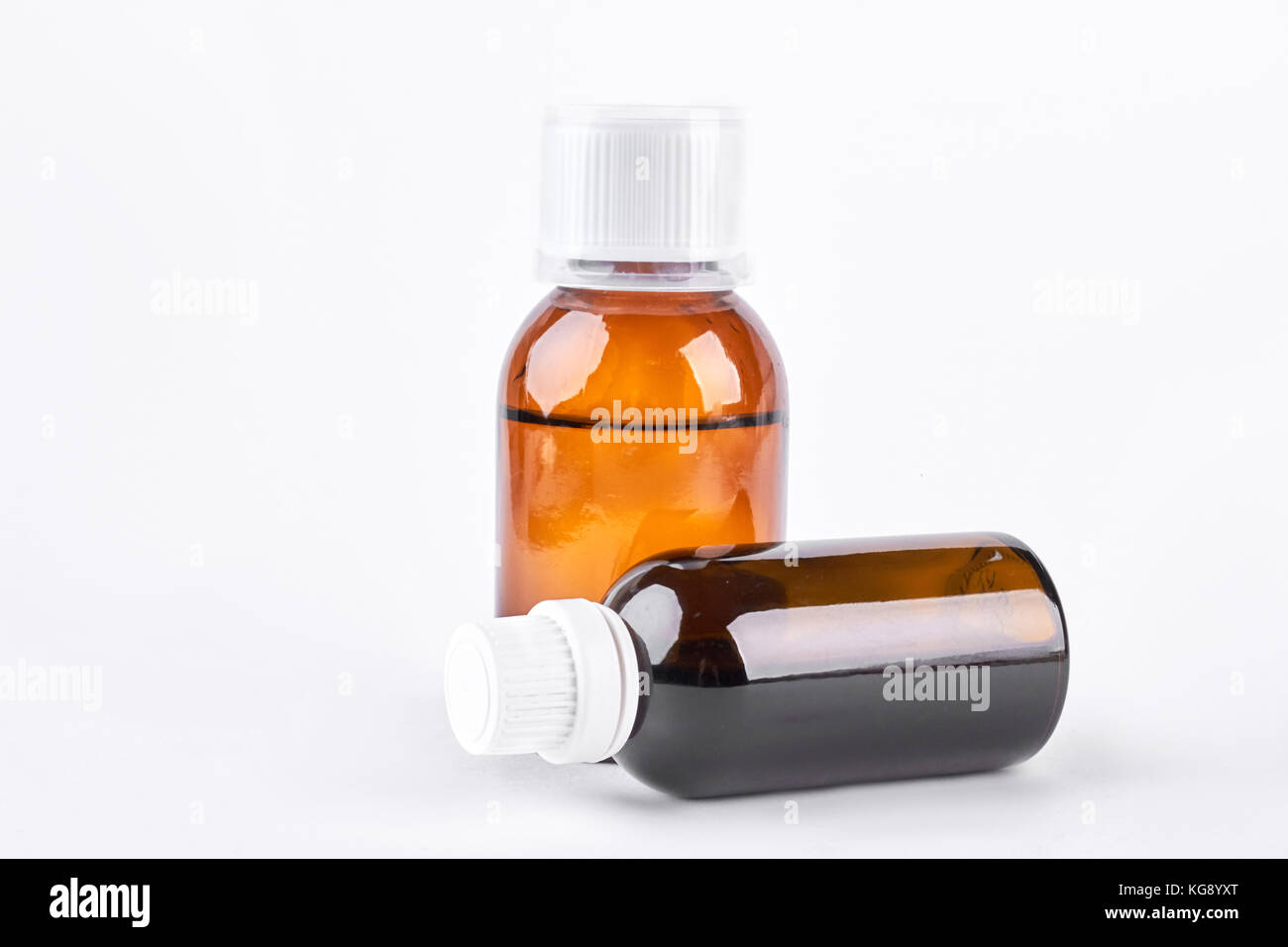 Two bottles with medical liquid, one lying Stock Photo - Alamy