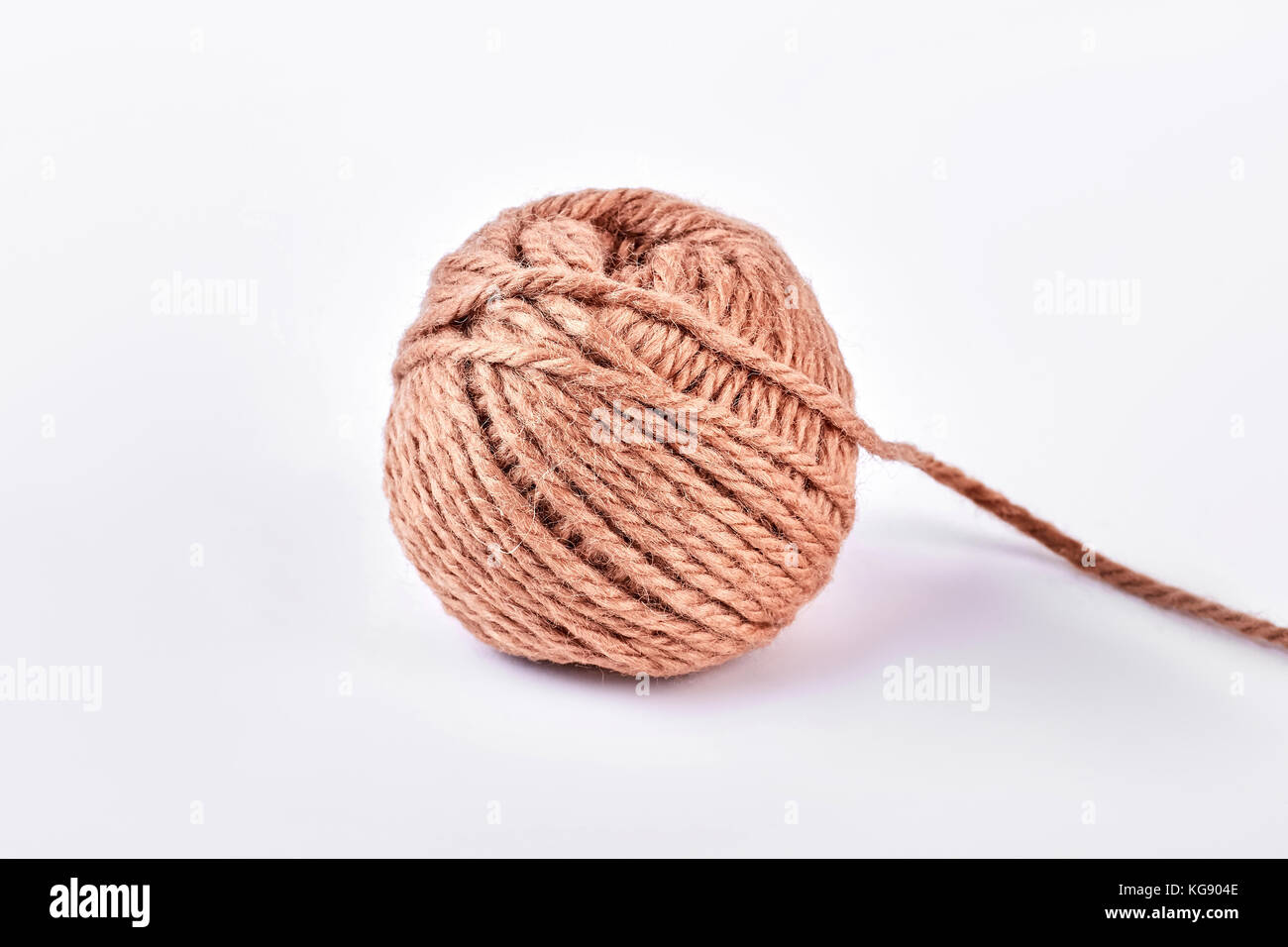Ball of brown yarn, white background Stock Photo - Alamy