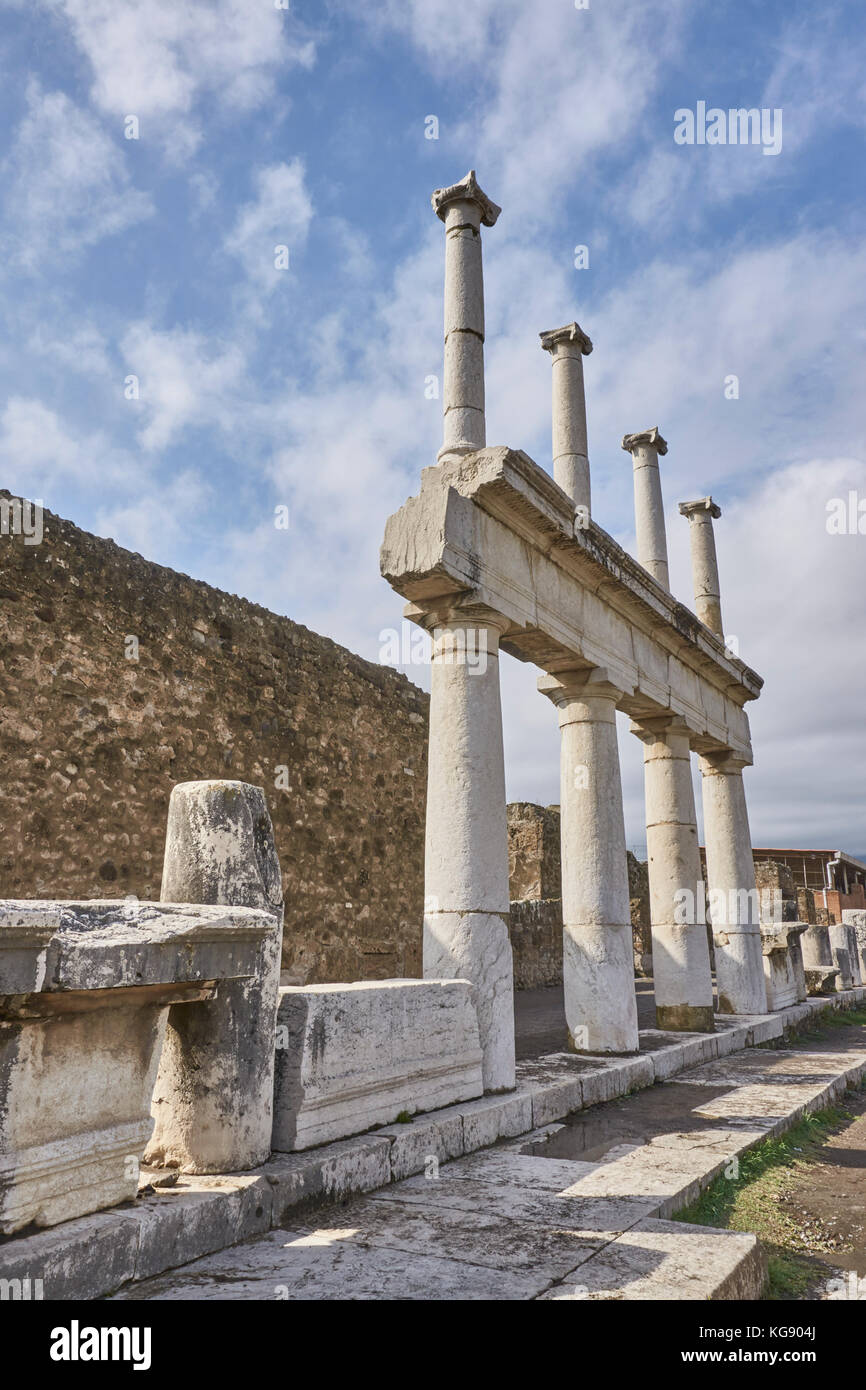 Pompeii ruins exhibited after archaeological excavations. Four columns supporting beam with four ...