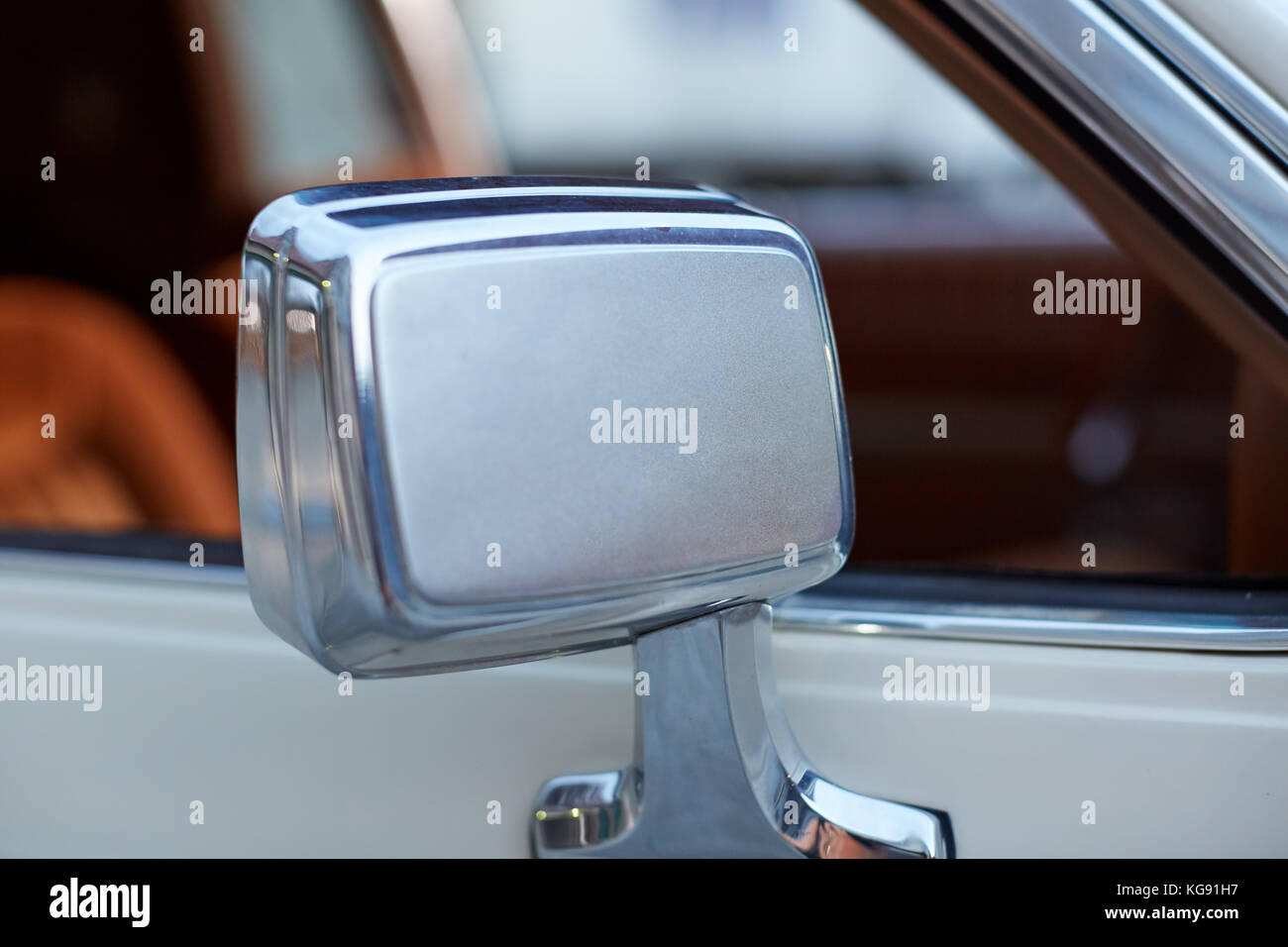 Side view mirror on a classic white vintage car with chrome and ...