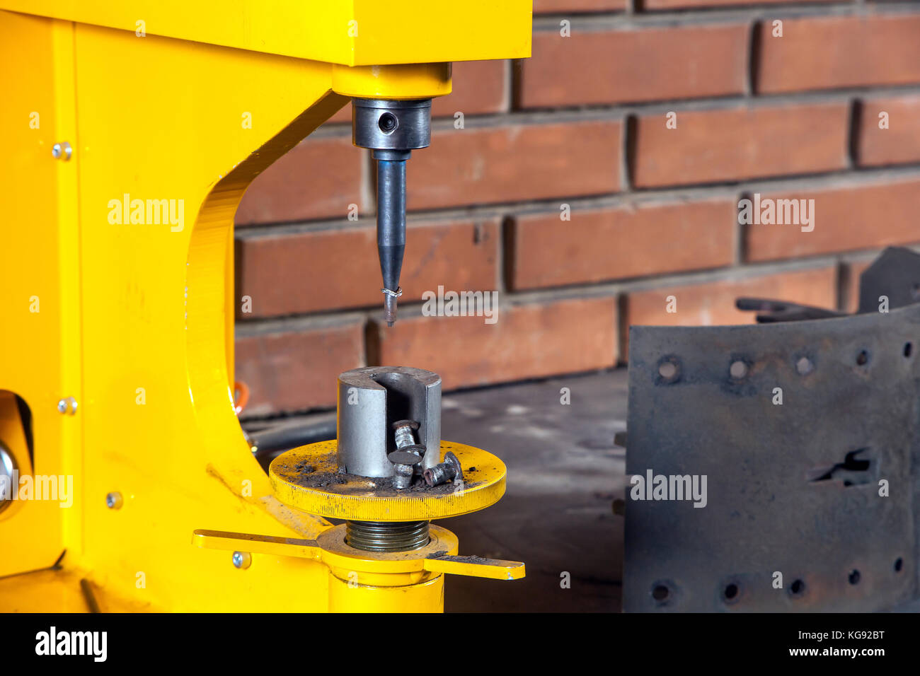 A close-up of yellow riveter machine for riveting brake pads in the ...
