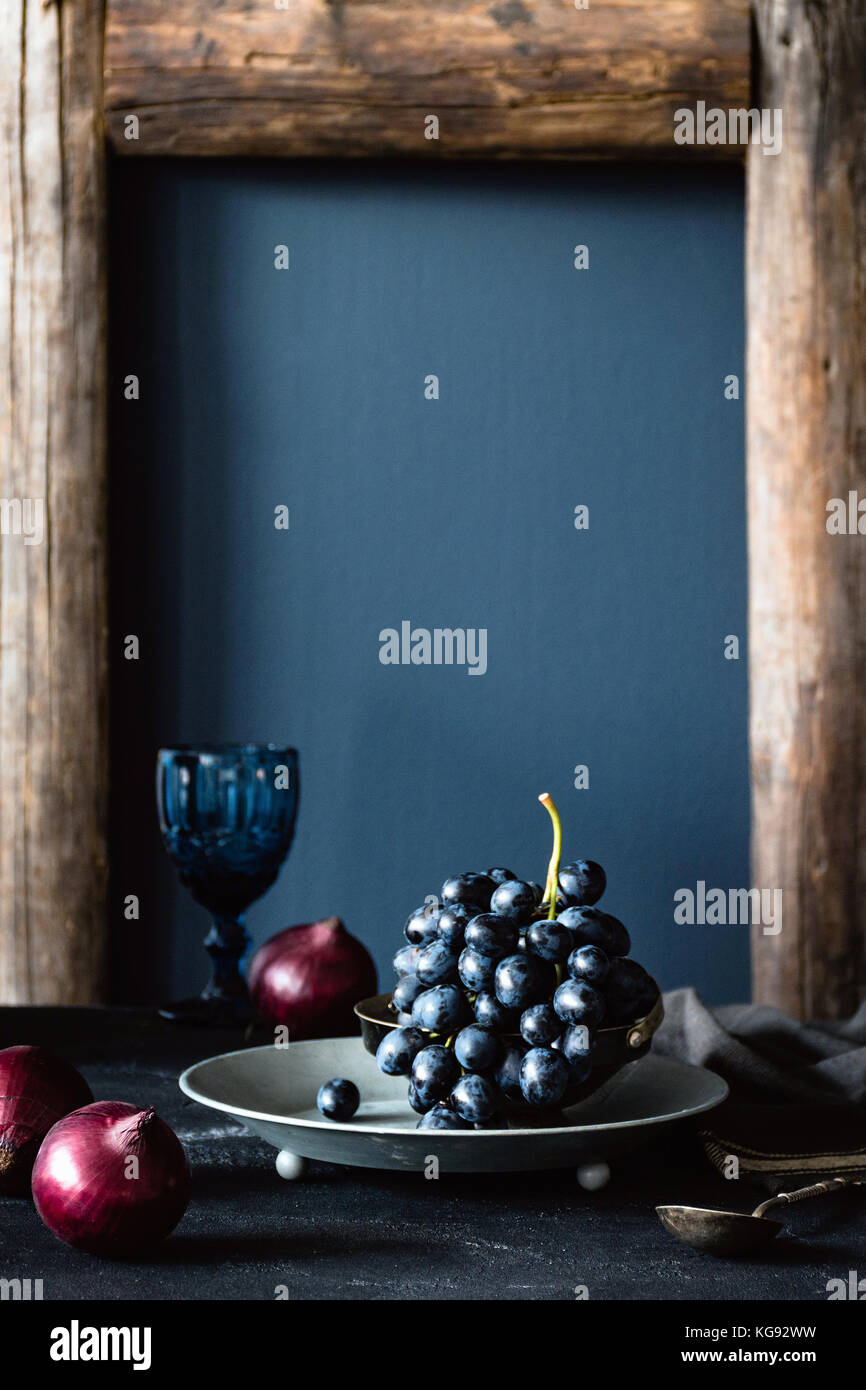 Black grapes on vintage silver tray still life. Vertical composition ...