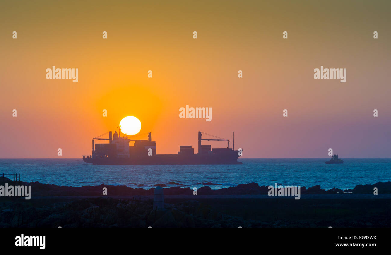Cargo ship at sunset Stock Photo - Alamy