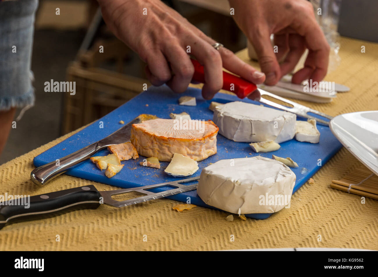 Person cutting cheese on plate Stock Photo - Alamy