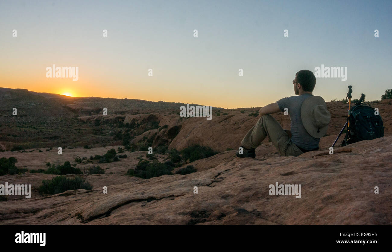 Man watching sunset in desert Stock Photo - Alamy
