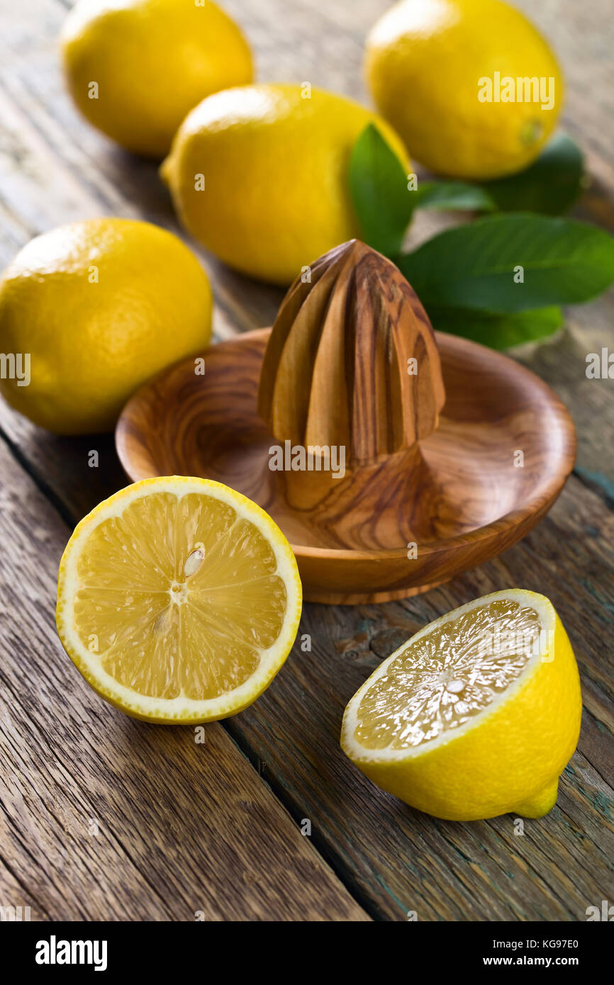 Juicy ripe lemons and old wooden squeezer Stock Photo - Alamy