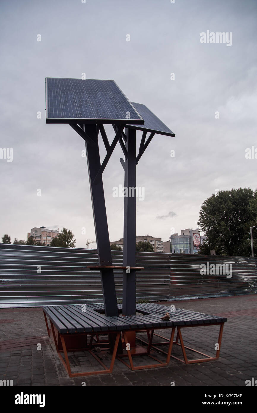 solar panels on a riser with benches for people. Building a park zone ...