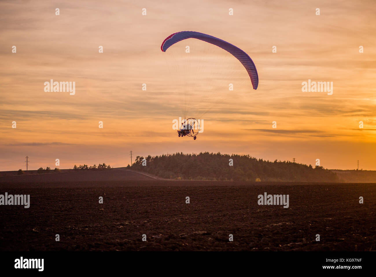 a double moparaplan flying over the field at sunset Stock Photo - Alamy