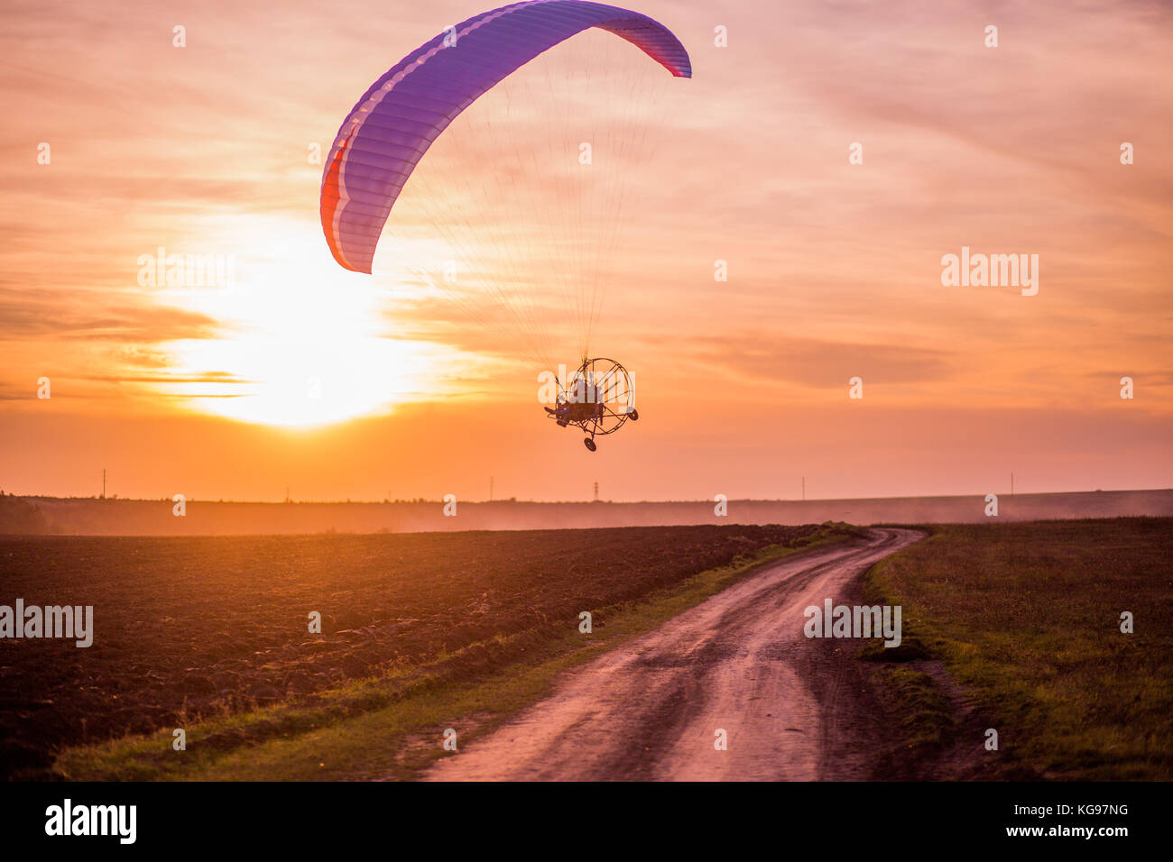 a double moparaplan flying over the field at sunset Stock Photo - Alamy