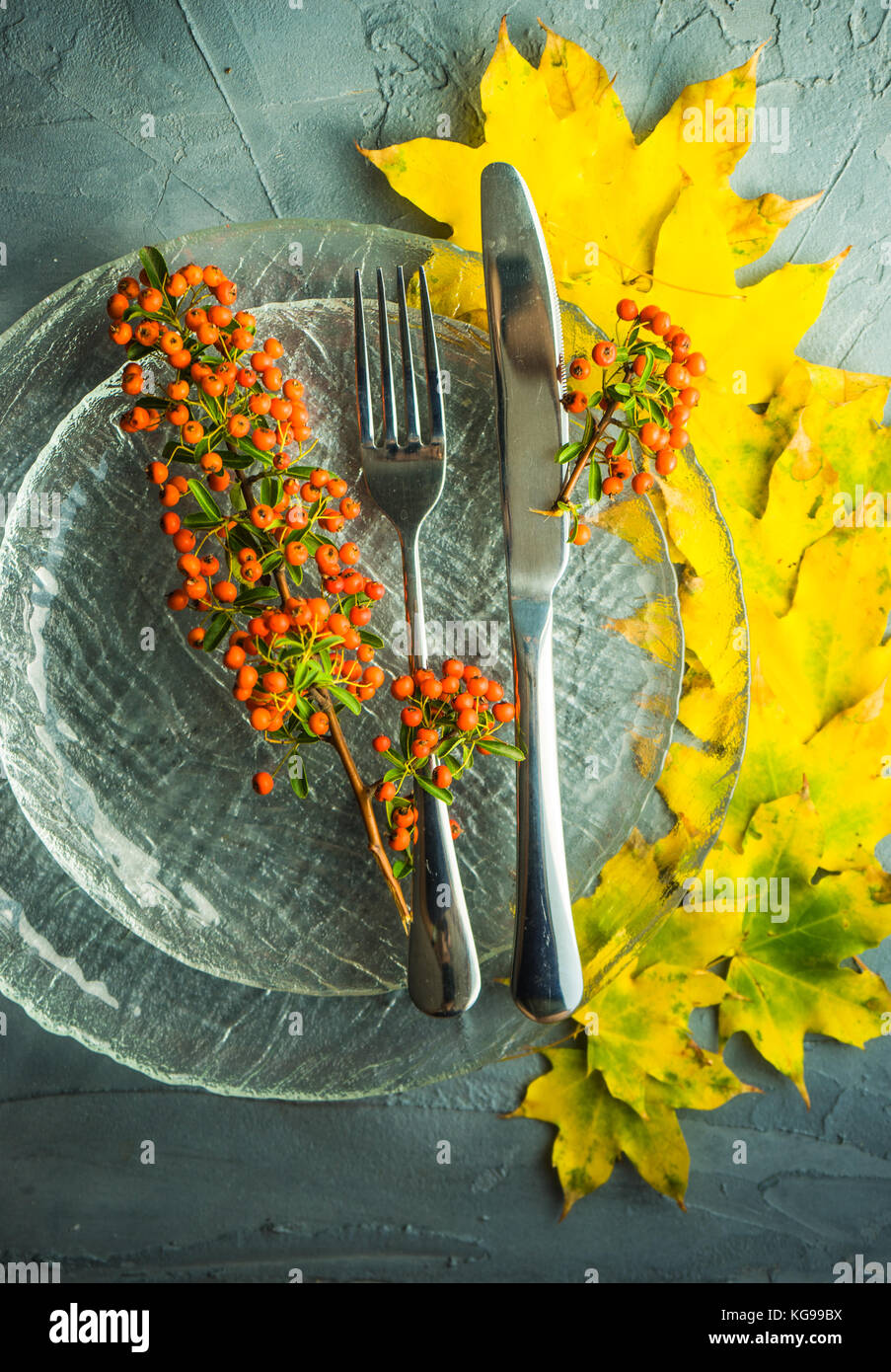 Autumnal table setting with bright red and orange wild berries on ...