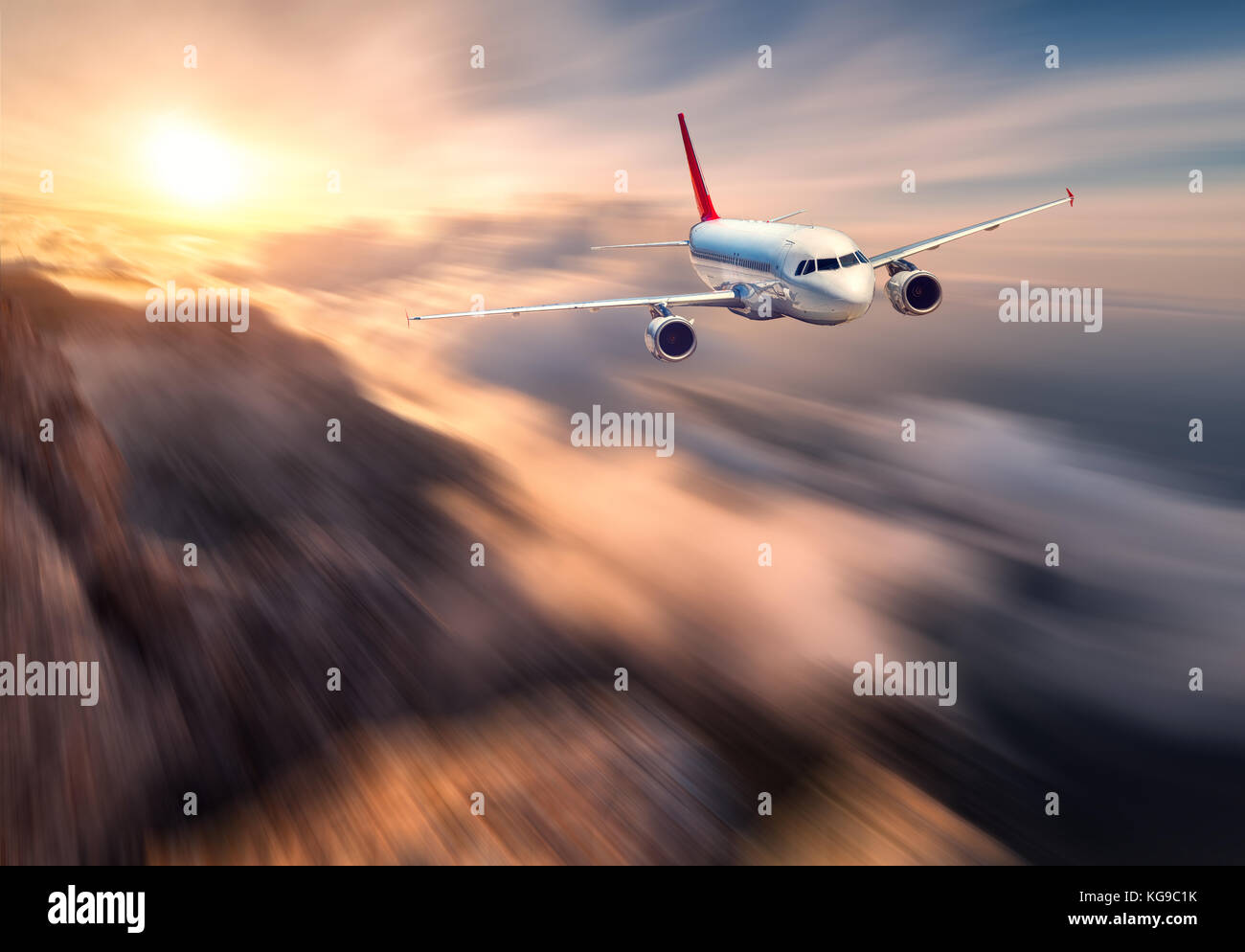 Amazing airplane mith motion blur effect is flying over low clouds at ...