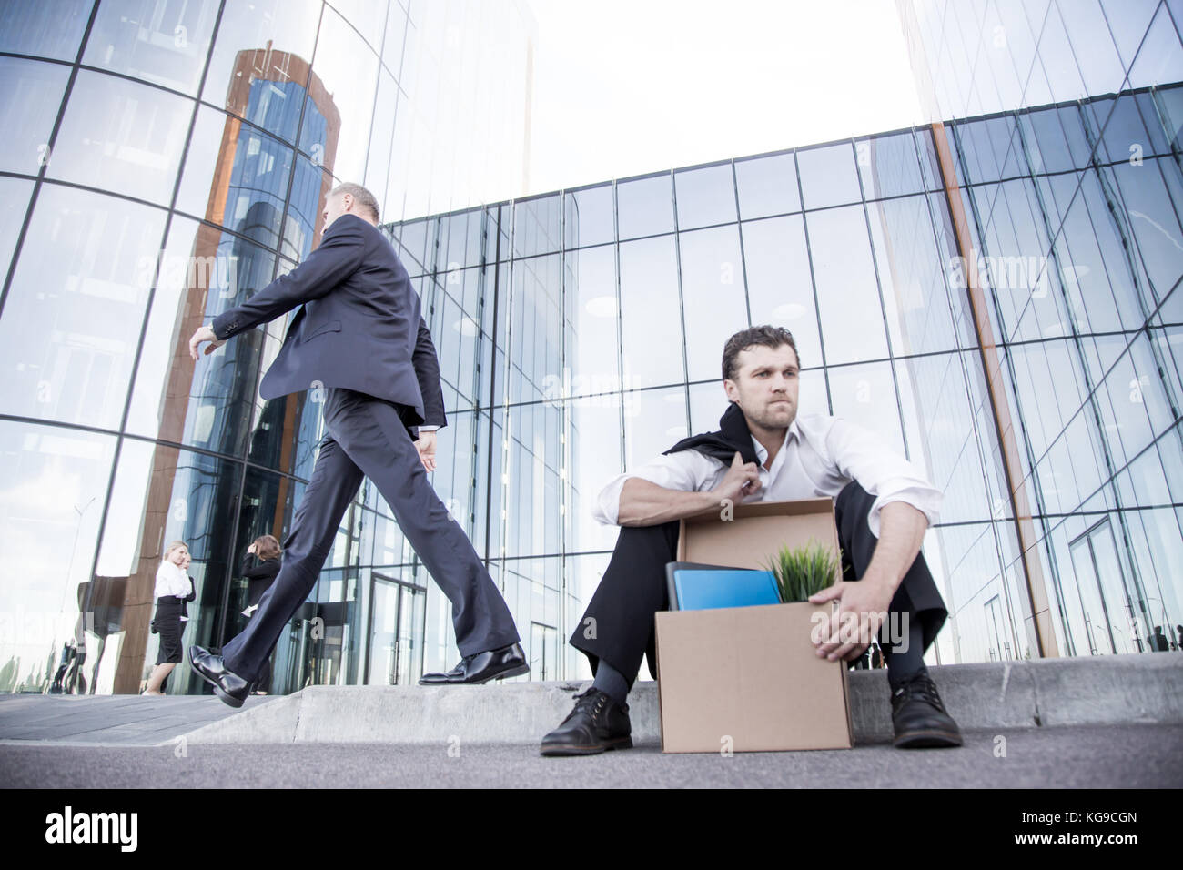 Fired business man sitting frustrated and upset on the street near ...