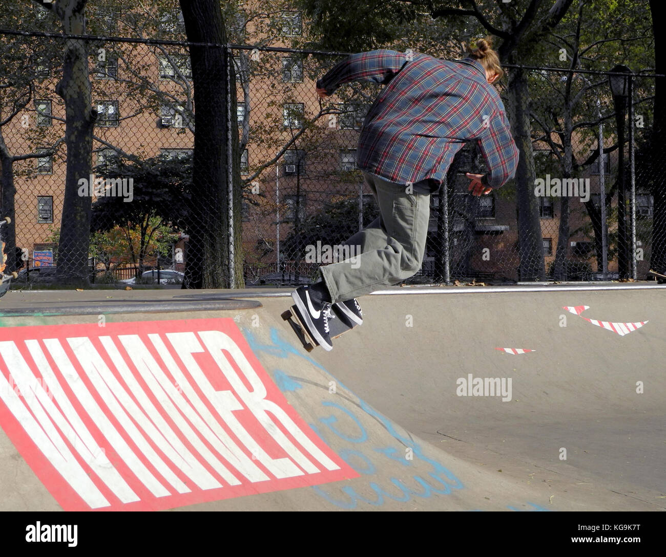 Skaters skate in a skatepark over ramps of a parcour adorned with edgy ...