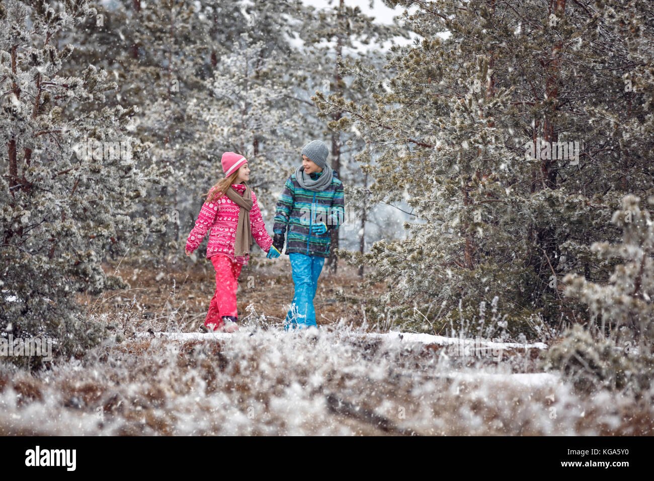 little happy boy and girl walking in snowy mountain Stock Photo - Alamy