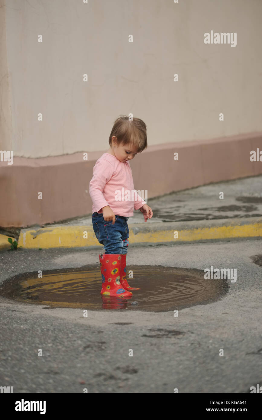 little girl plays in the puddle outdoors Stock Photo - Alamy