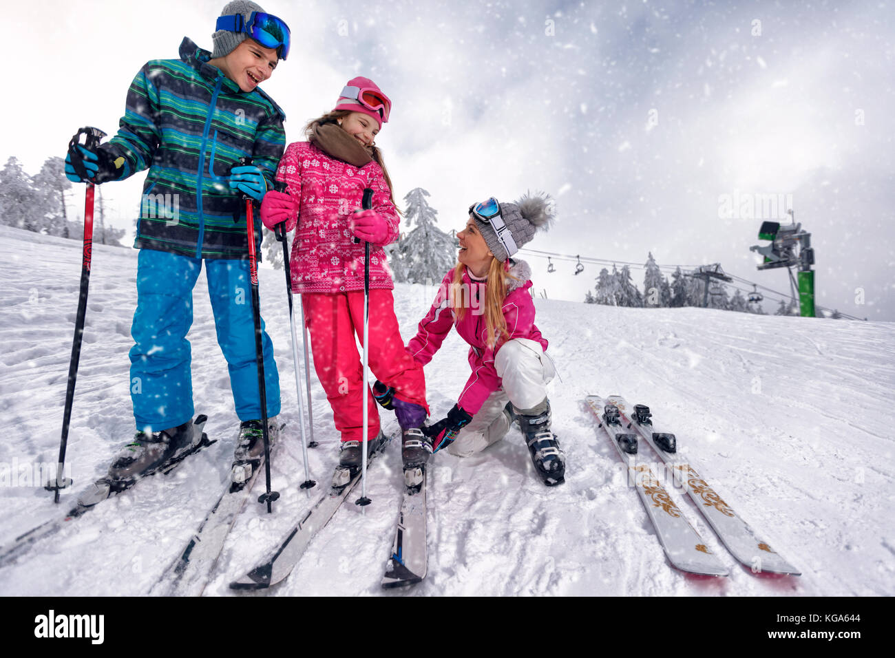 mother preparing for skiing her happy children on ski resort Stock ...