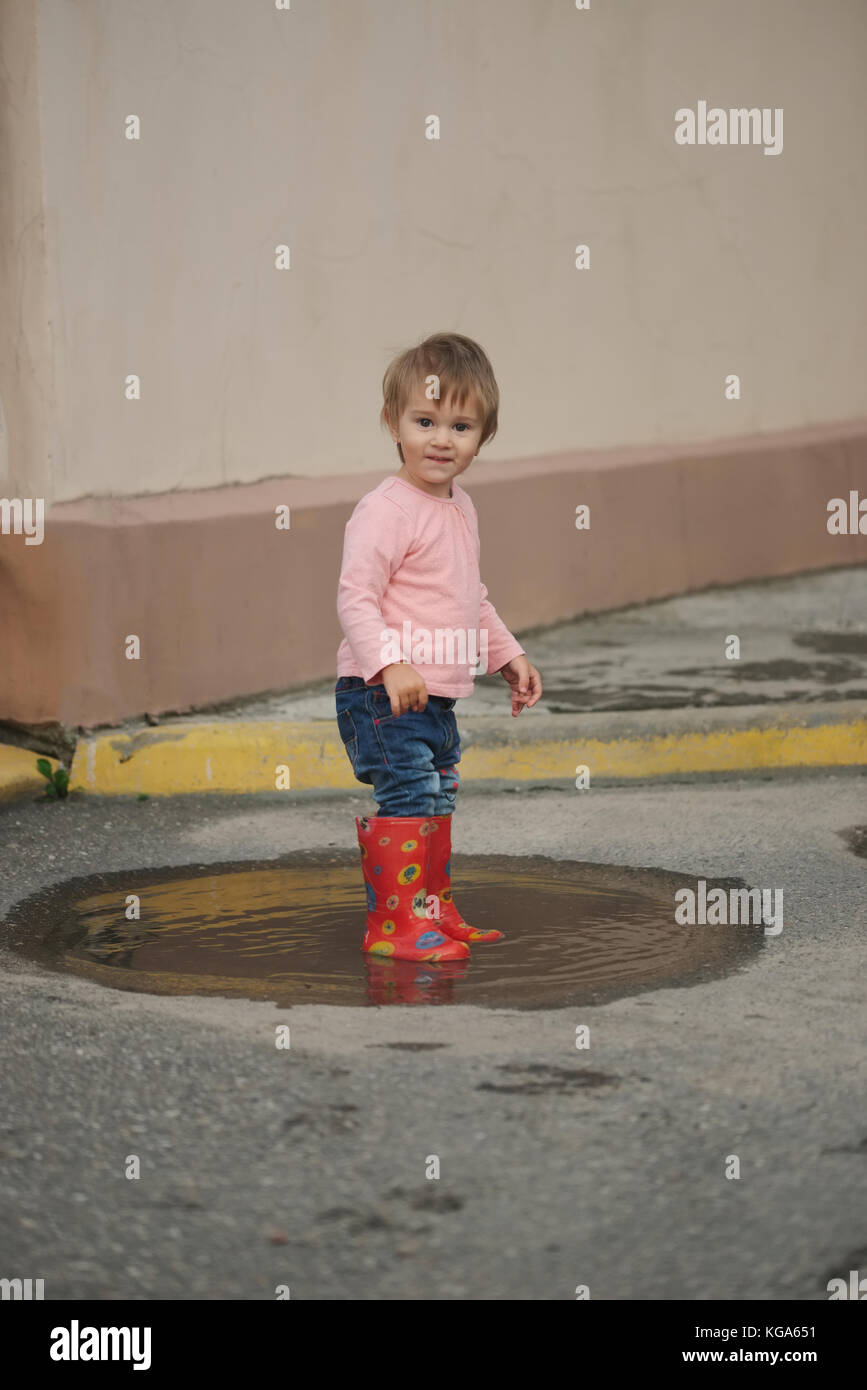little girl plays in the puddle outdoors Stock Photo - Alamy