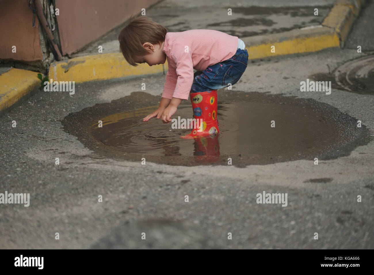 little girl plays in the puddle outdoors Stock Photo - Alamy