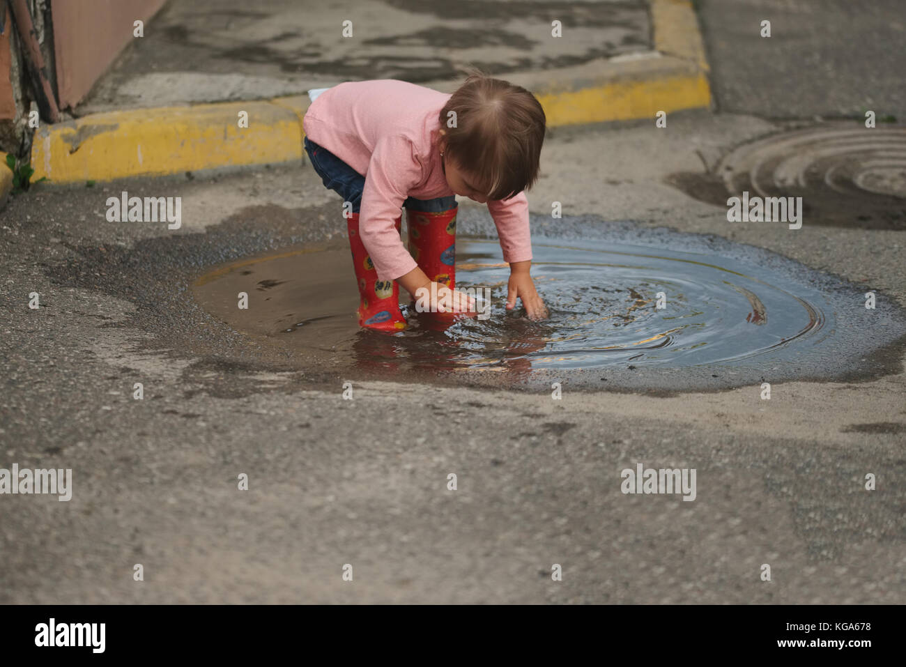 little girl plays in the puddle outdoors Stock Photo - Alamy