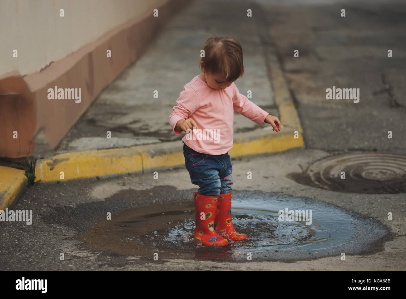 little girl plays in the puddle outdoors Stock Photo - Alamy