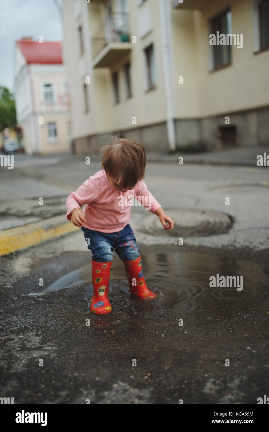 little girl plays in the puddle outdoors Stock Photo - Alamy