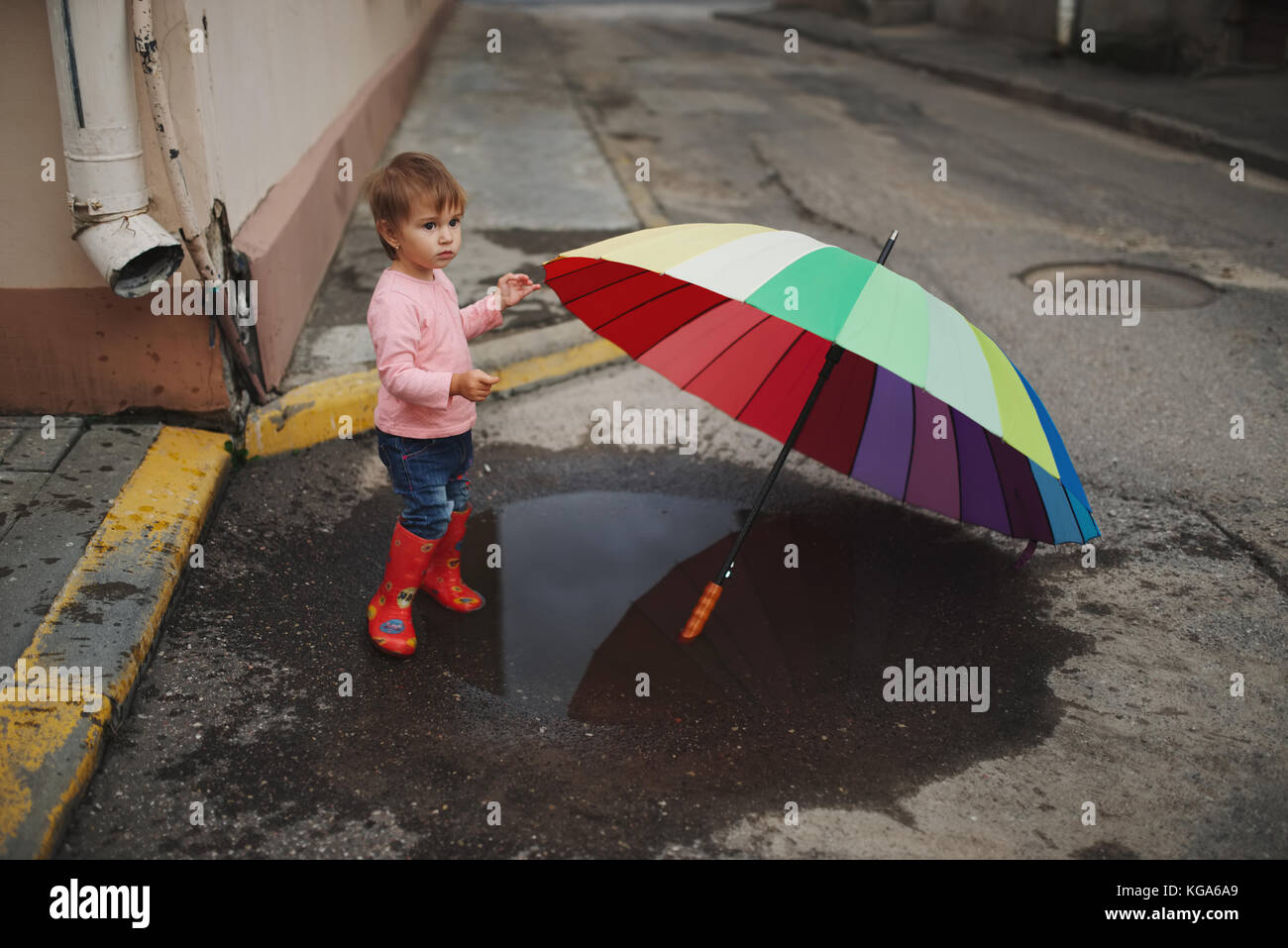 little girl plays in the puddle outdoors Stock Photo - Alamy