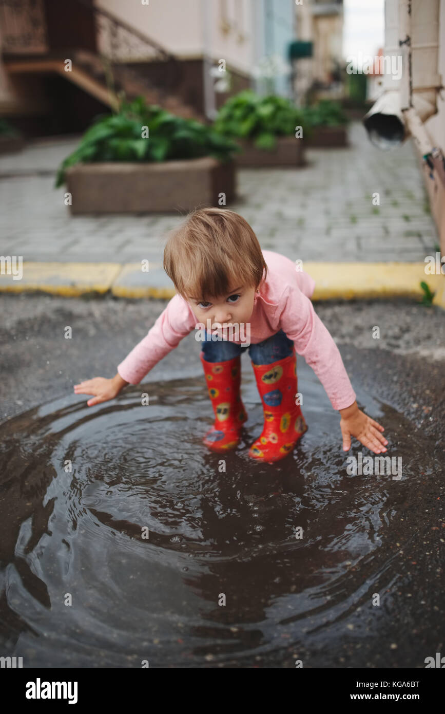 little girl plays in the puddle outdoors Stock Photo - Alamy