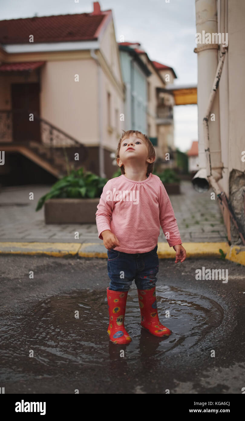 little girl plays in the puddle outdoors Stock Photo - Alamy