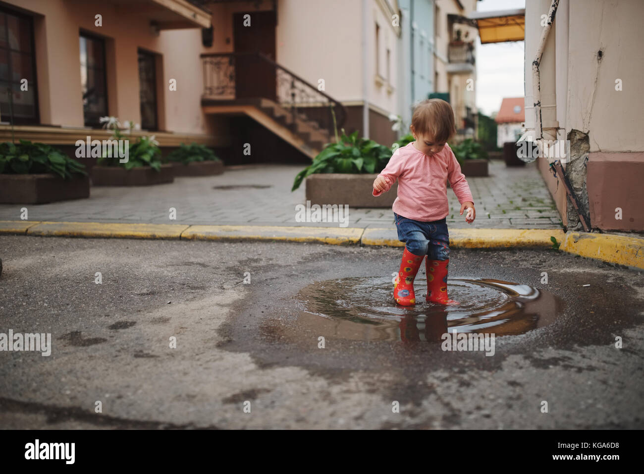 little girl plays in the puddle outdoors Stock Photo - Alamy