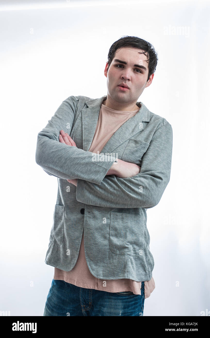 Fair skinned young man looking serious with arms crossed in casual ...