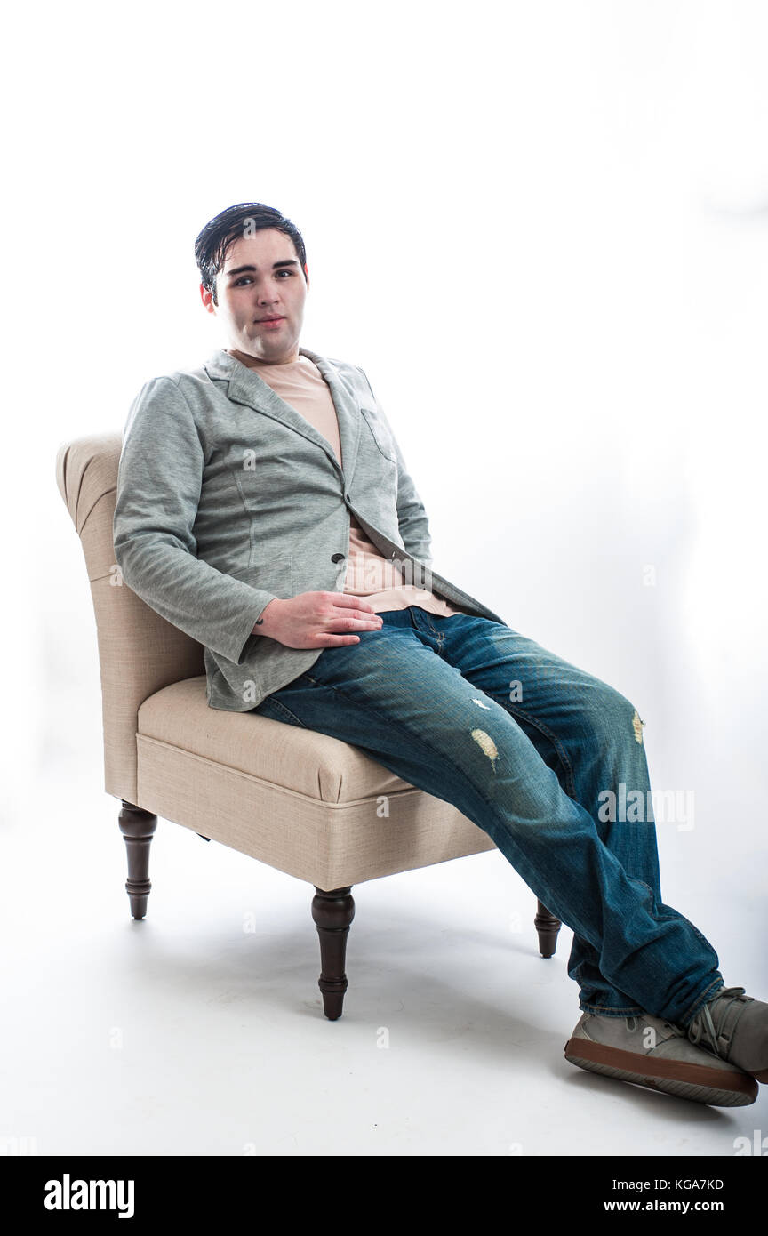 Young man leaning back in comfortable chair looking relaxed and calm ...