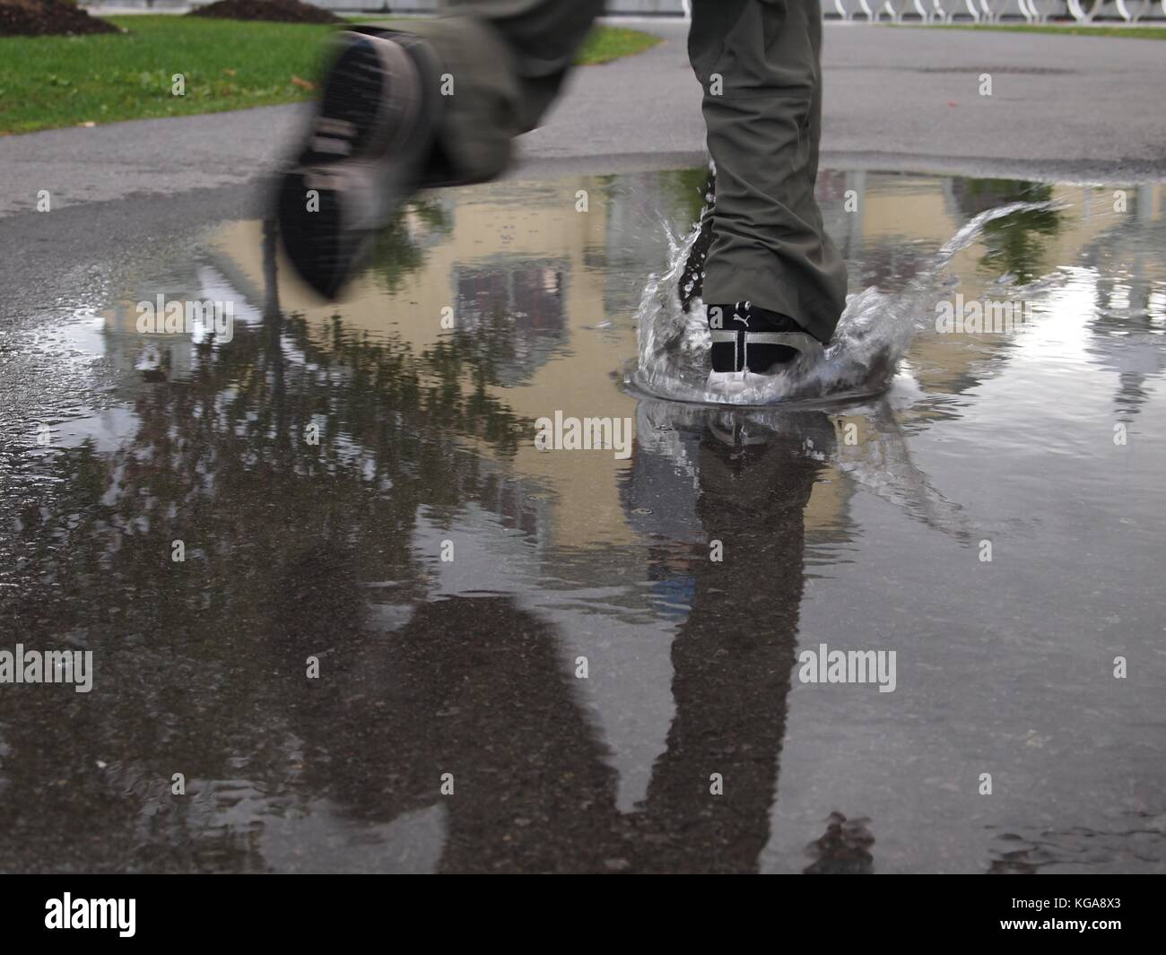 A child runs through a puddle, in which is reflected the Aberdeen ...