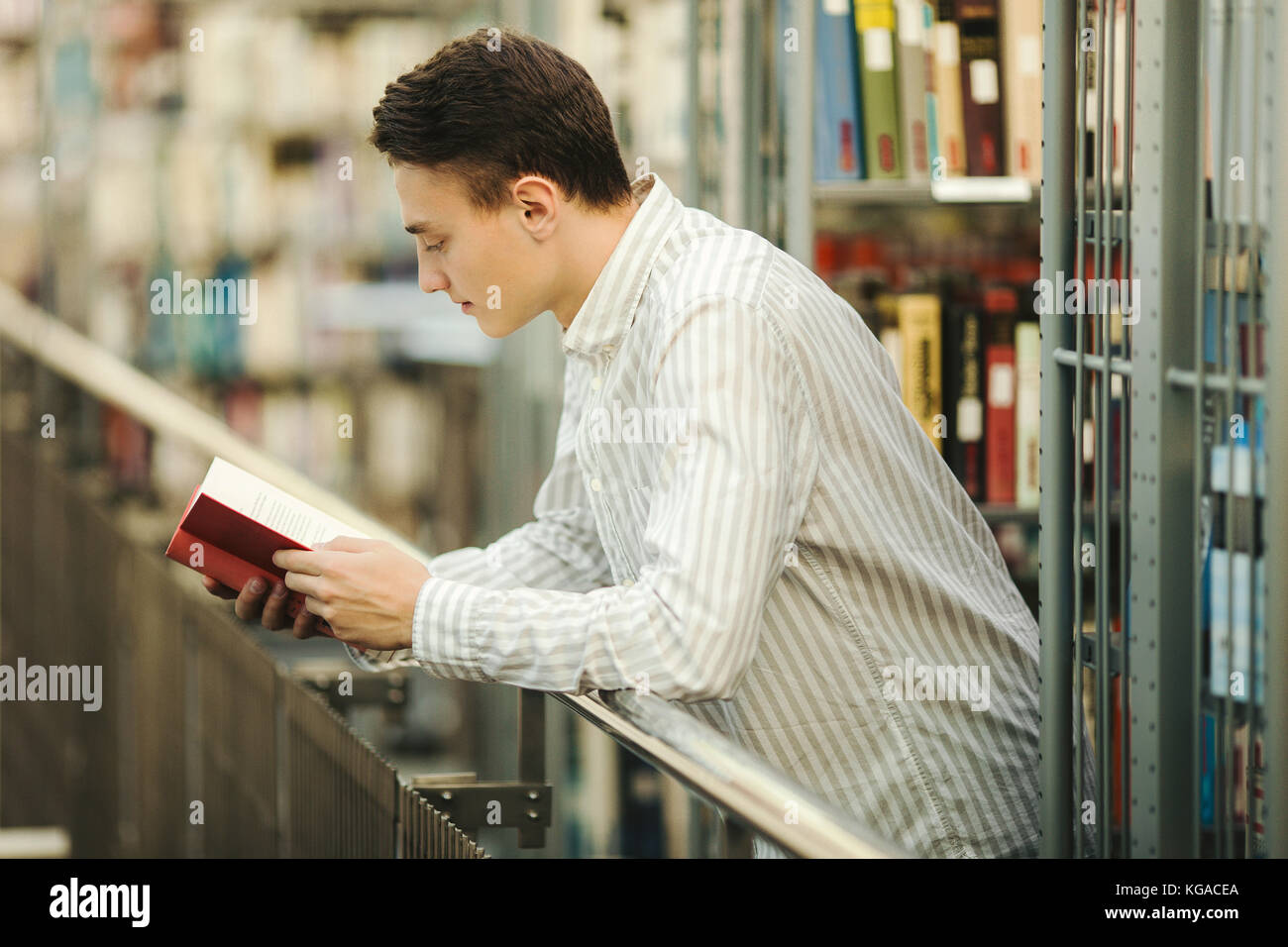 Man stsnd on the library and read book with blur background sun light ...