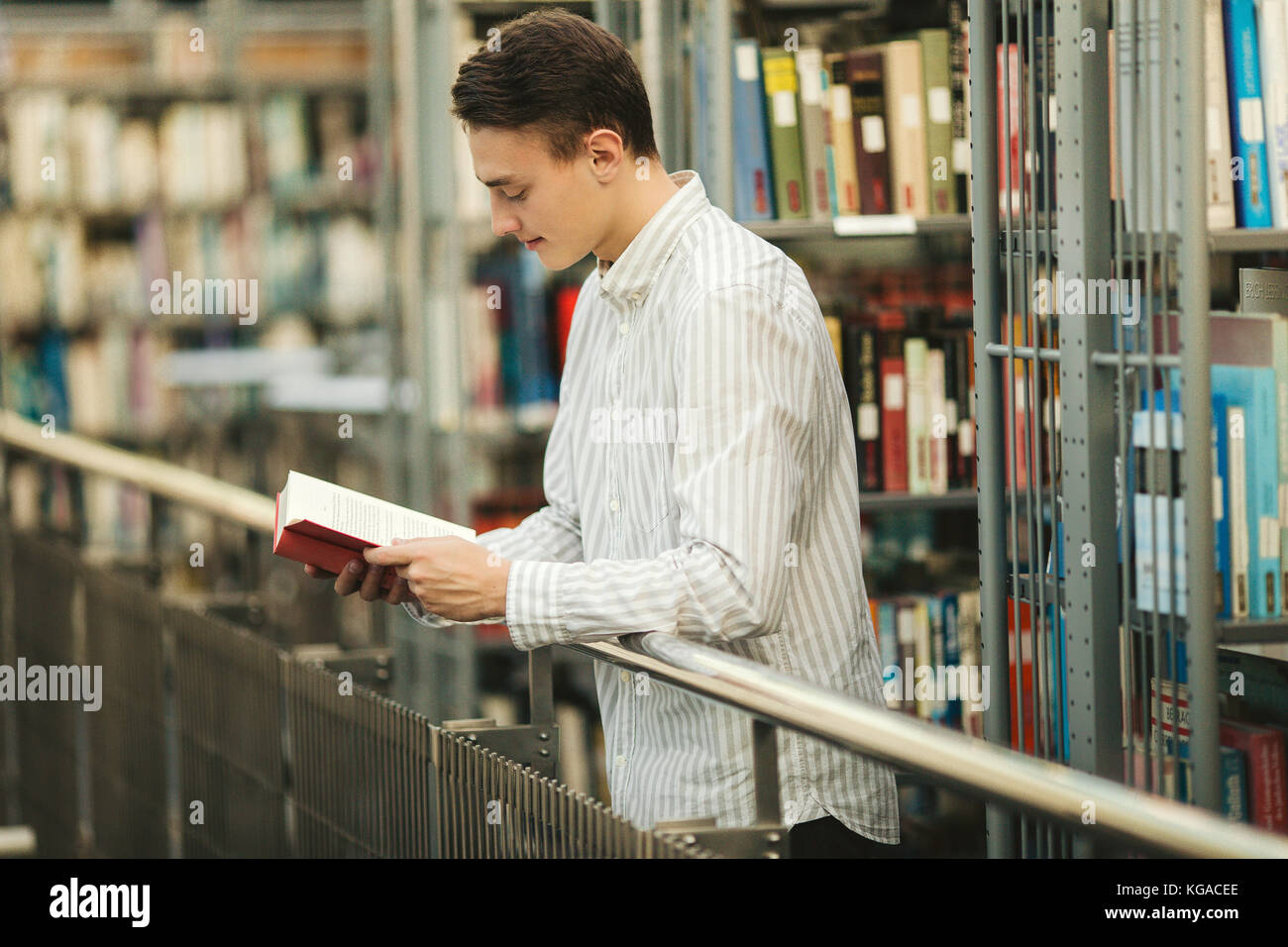 Man stsnd on the library and read book with blur background sun light ...
