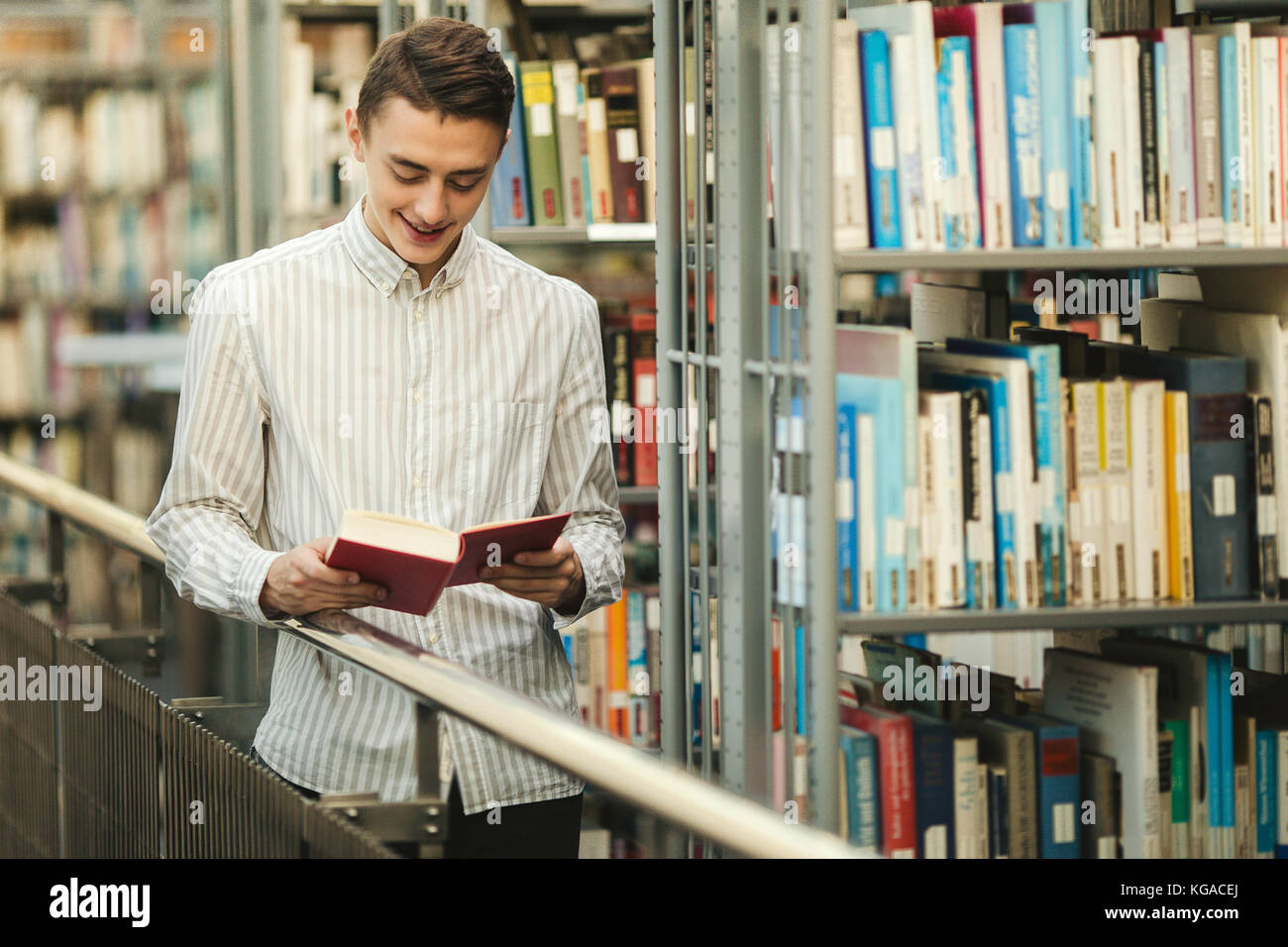 Man stsnd on the library and read book with blur background sun light ...