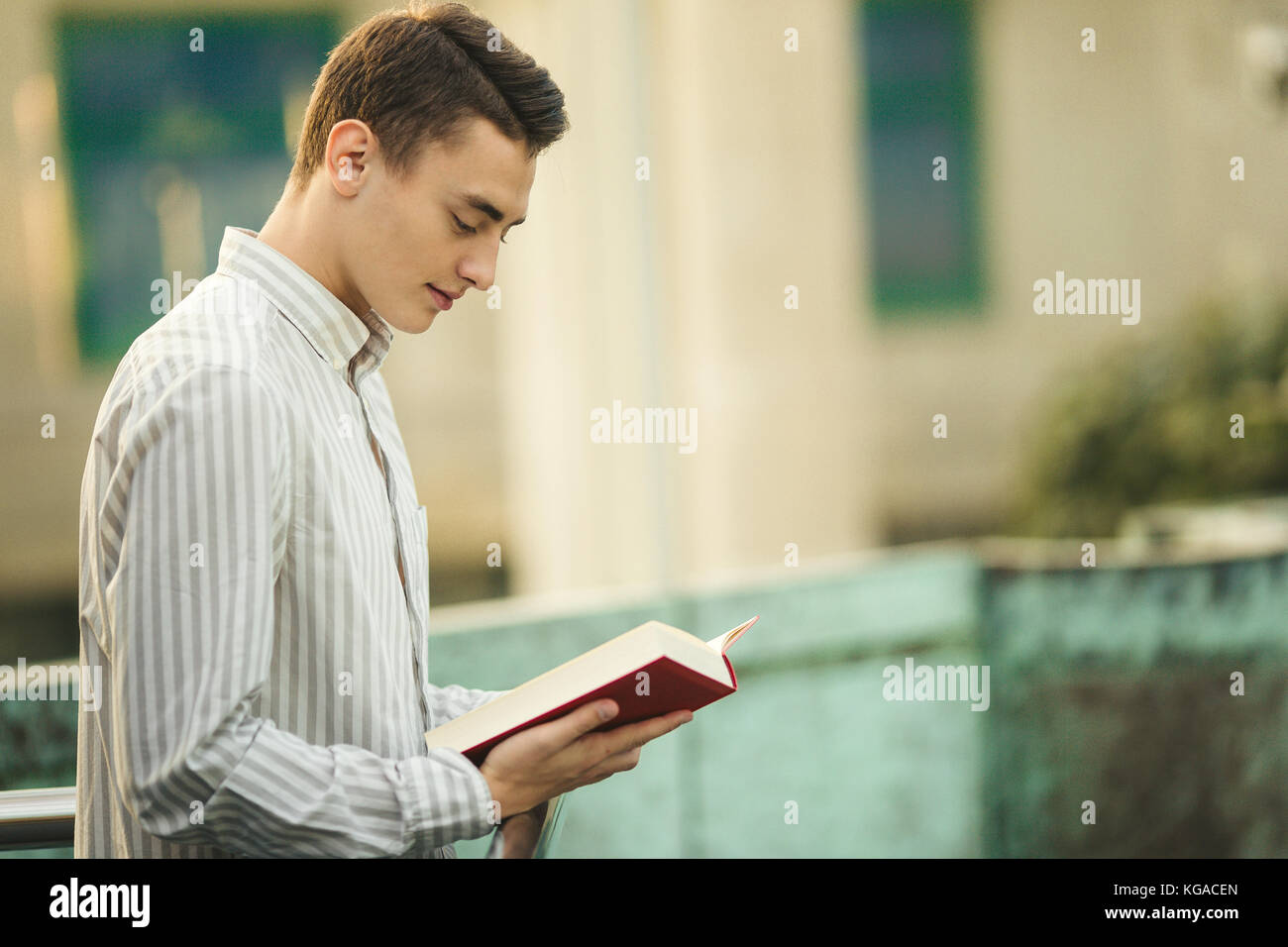 Man stsnd on the library and read book with blur background sun light ...