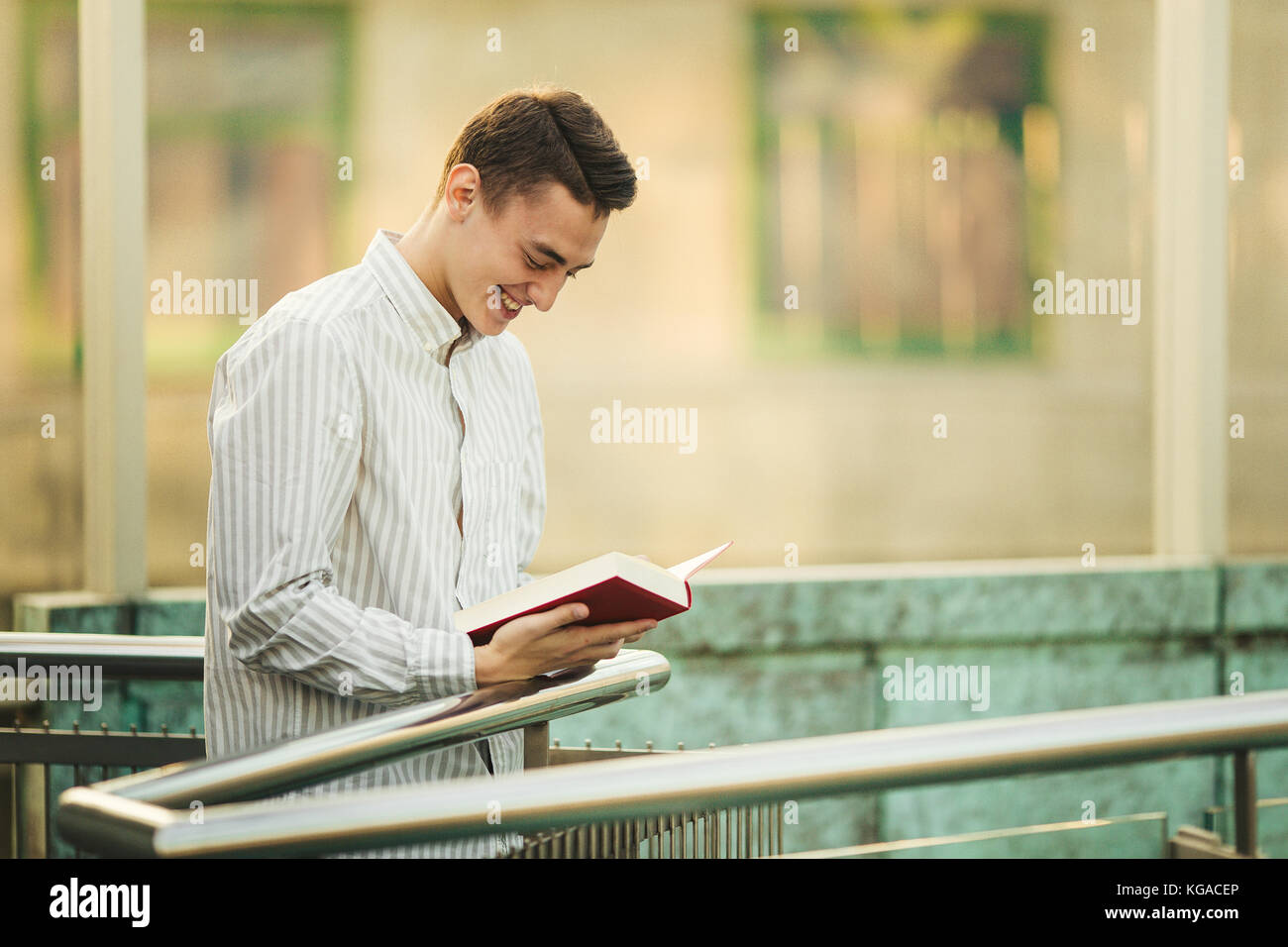 Man stsnd on the library and read book with blur background sun light ...