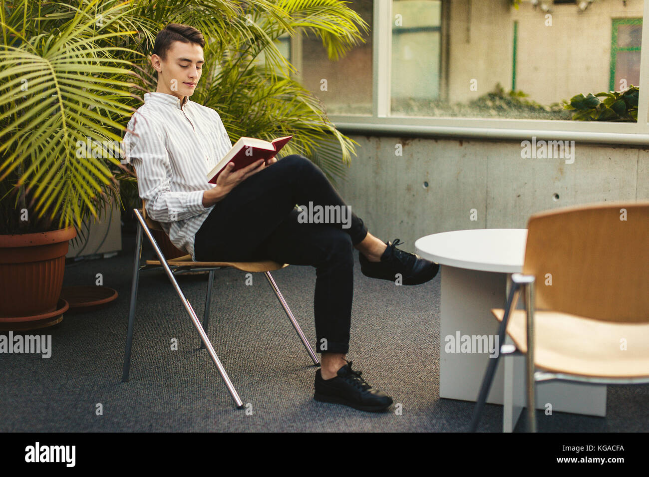 Man sit on the library and read book with blur background Stock Photo ...