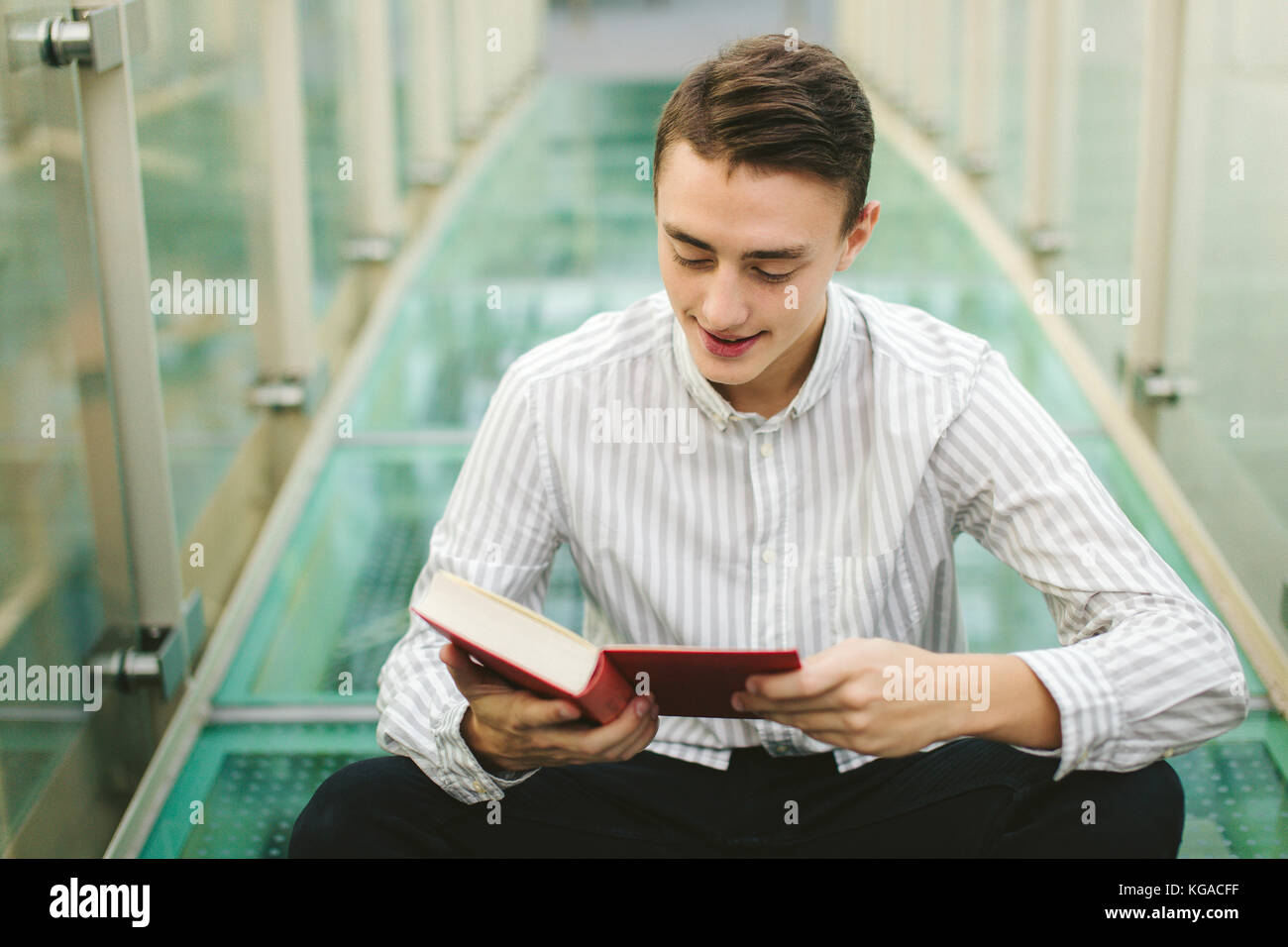 Man sit on the library and read book with blur background Stock Photo ...