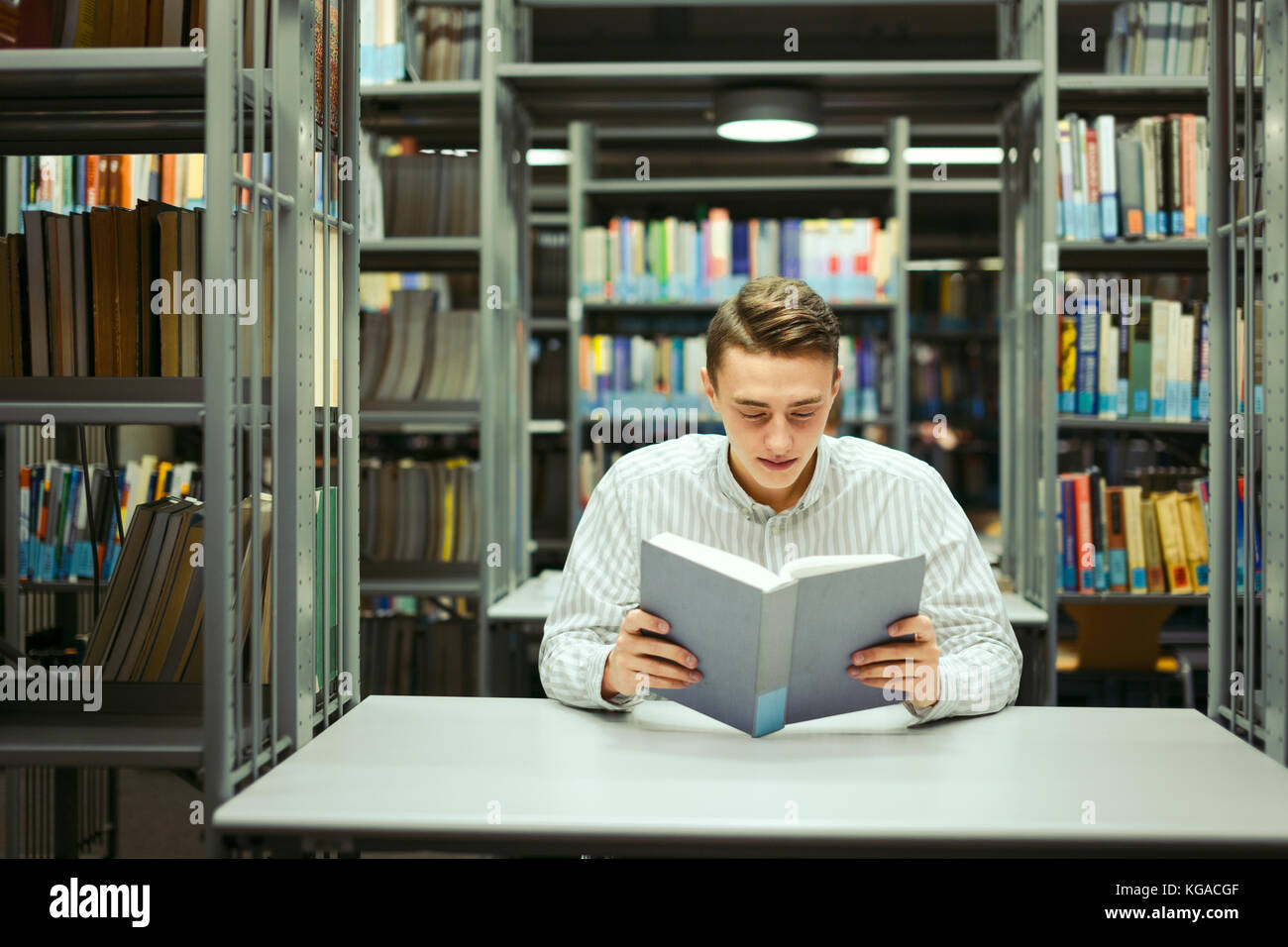 Man sit on the library and read book with blur background Stock Photo ...