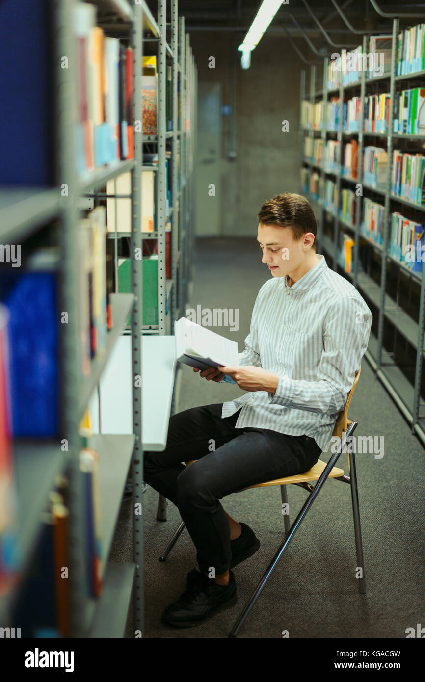 Man sit on the library and read book with blur background Stock Photo ...