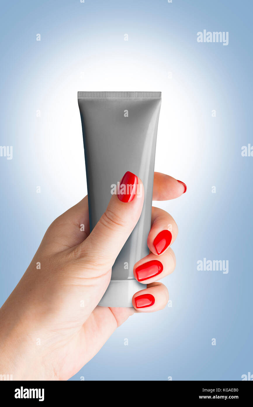 Plastic tube for cosmetics and body care in a female hand, isolated ...