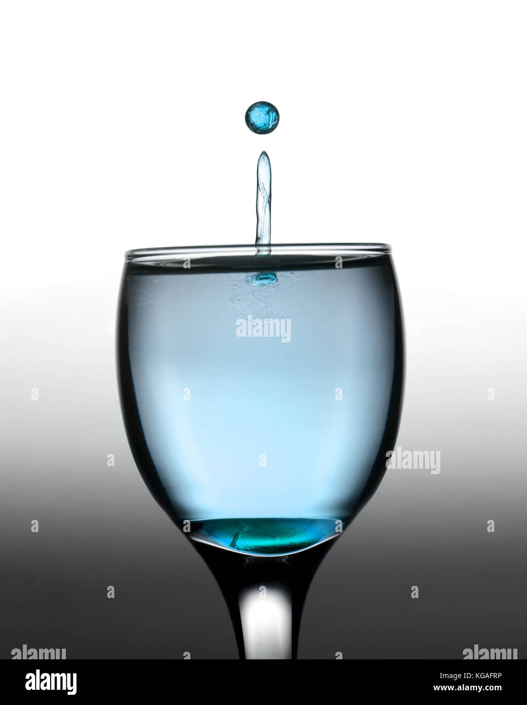 Colored water drop splash in crystal wine glass Stock Photo - Alamy