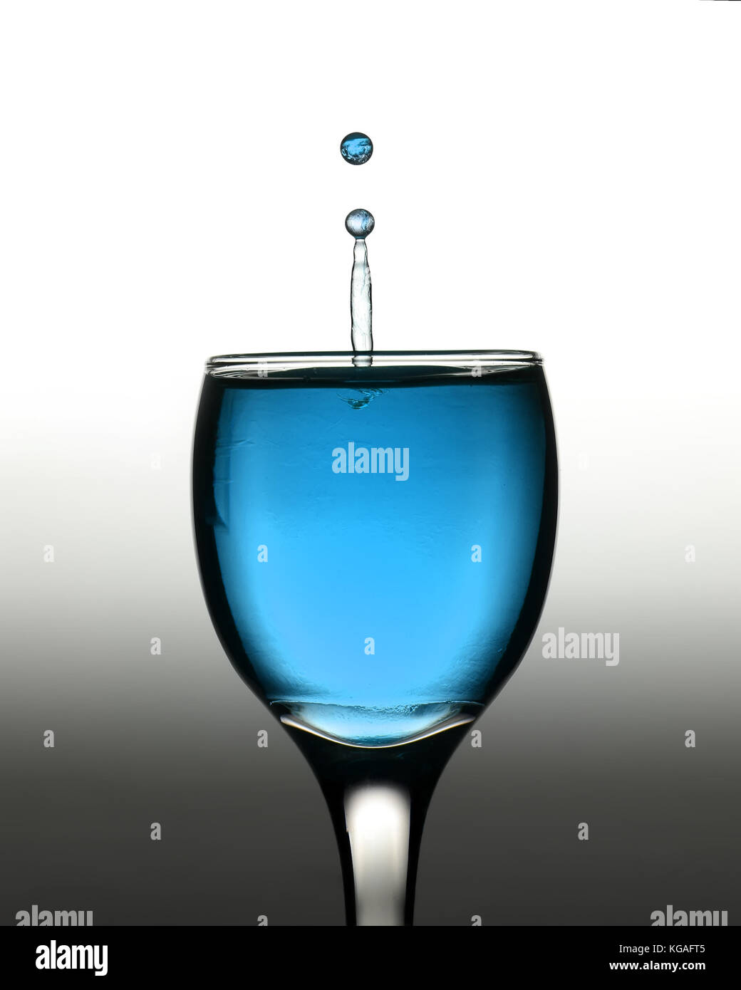 Colored water drop splash in crystal wine glass Stock Photo - Alamy