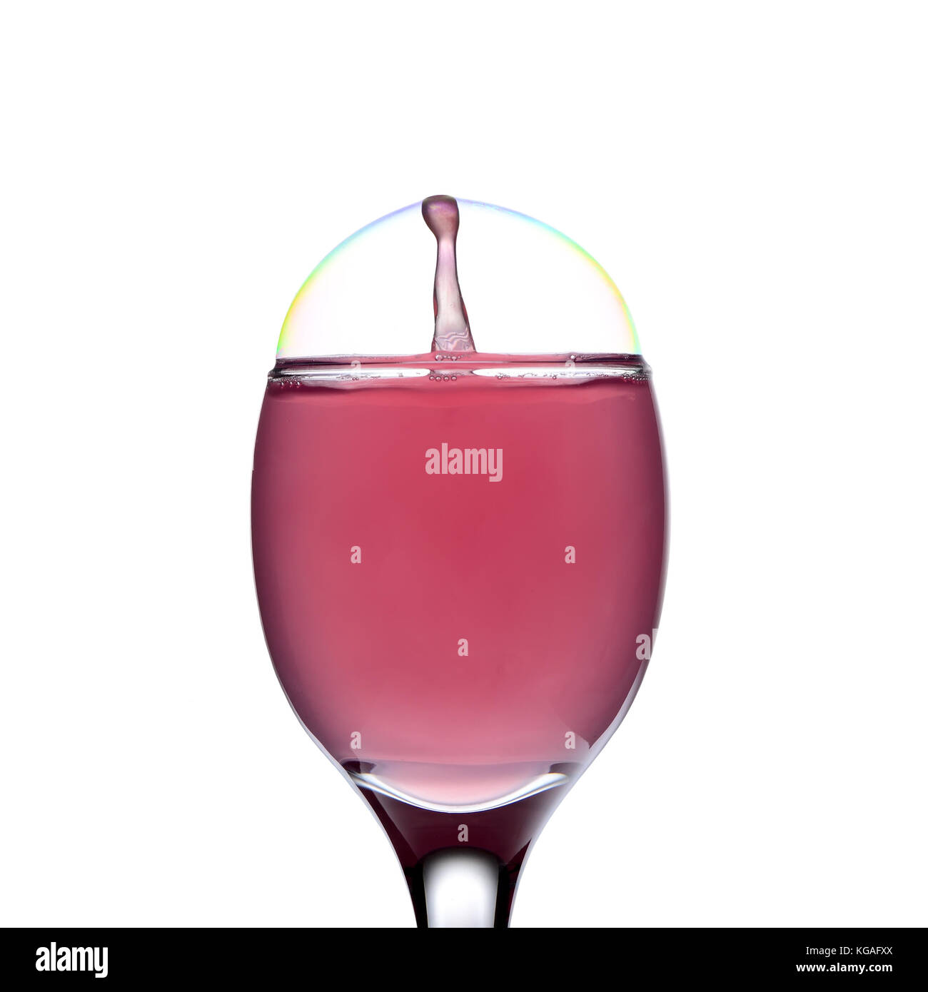 Colored water drop splash inside of soap bubble on crystal wine glass ...