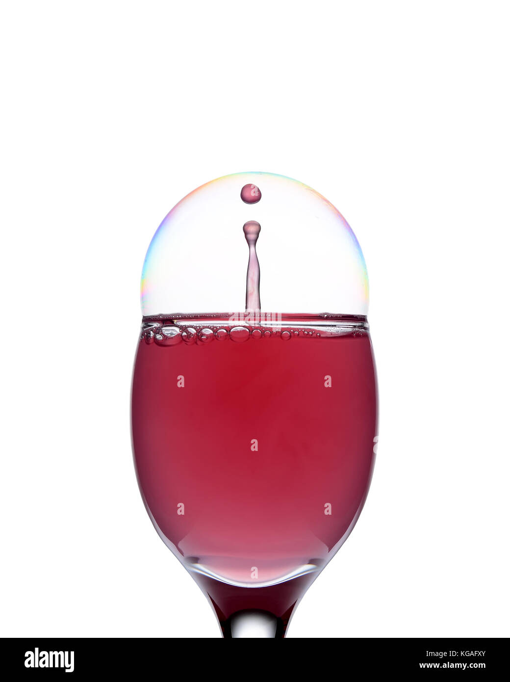 Colored water drop splash inside of soap bubble on crystal wine glass ...