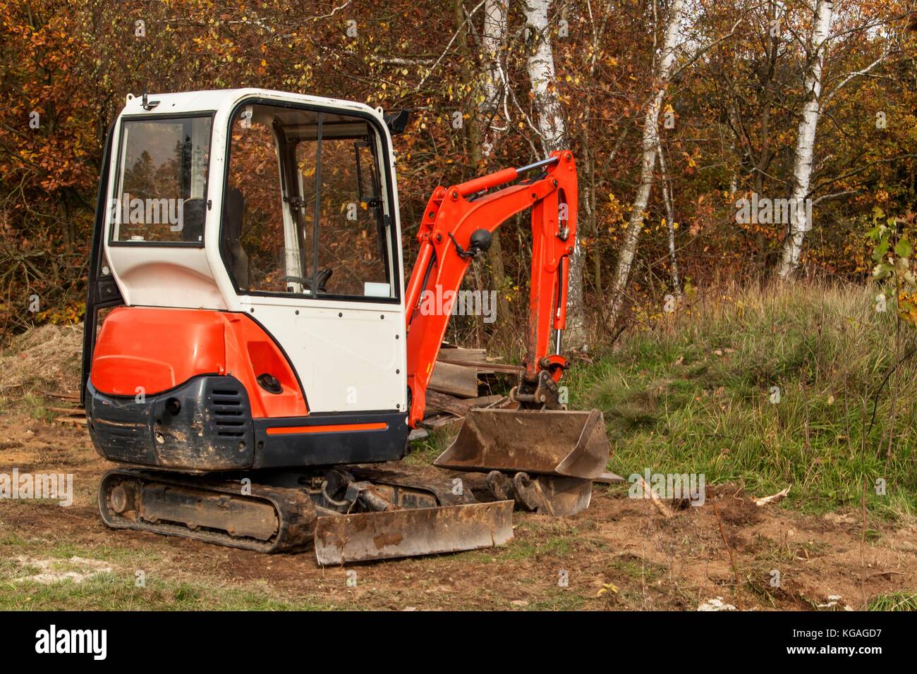 Mini excavator on a building site. Excavation work. The excavator works ...