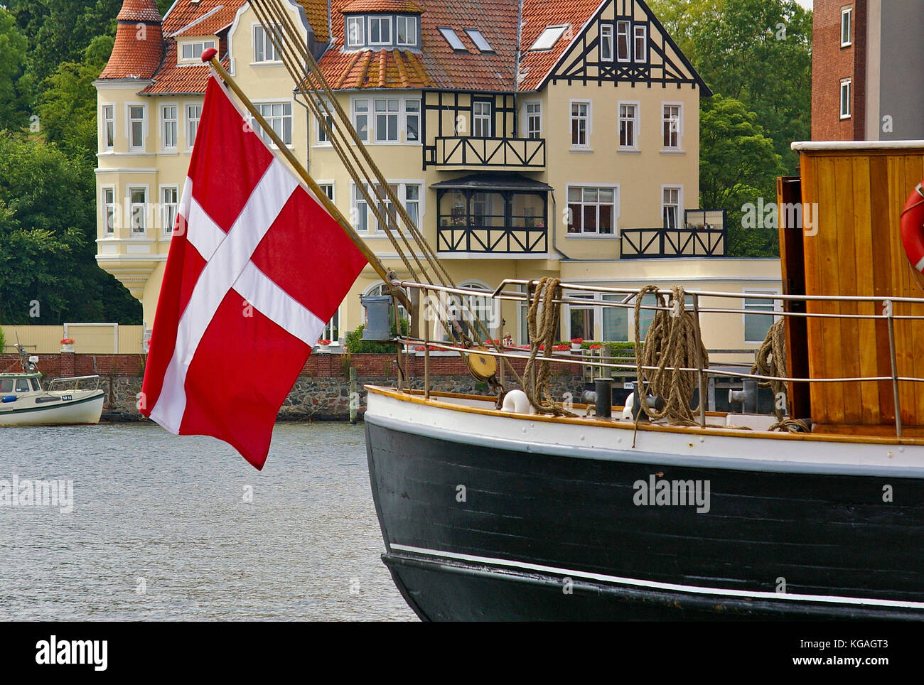 Stern of a traditional sailing ship with large danish flag hanging from ...